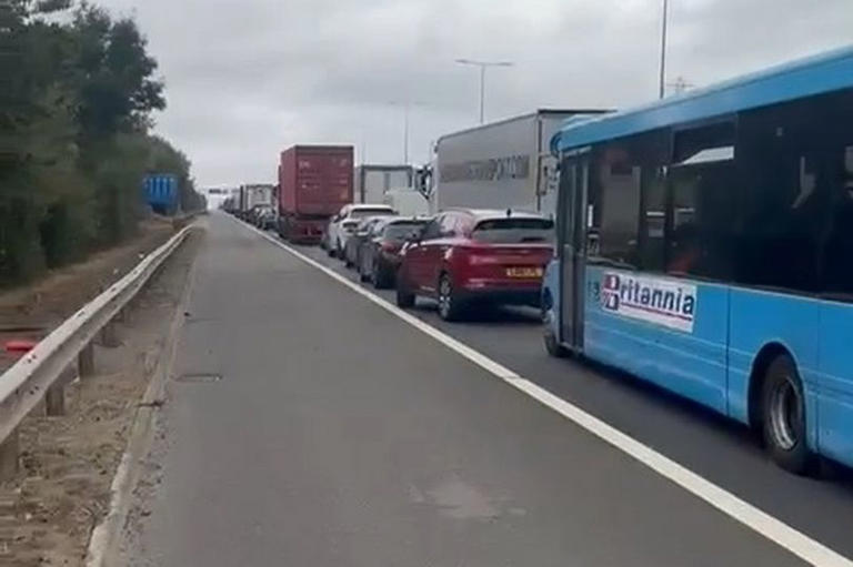 Couple ditch taxi and drag suitcases down motorway to catch holiday ...