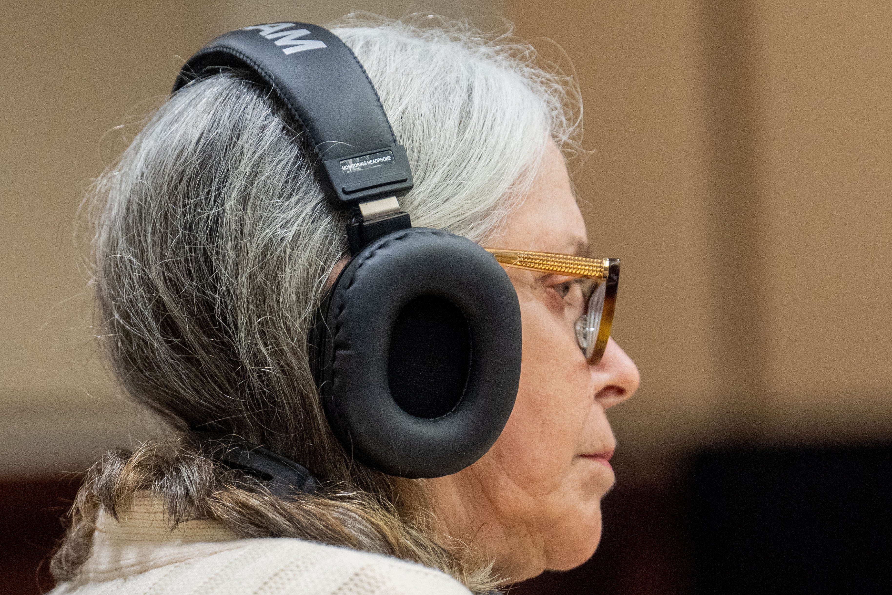 Why is Donna Adelson wearing headphones during the Dan Markel murder trial?