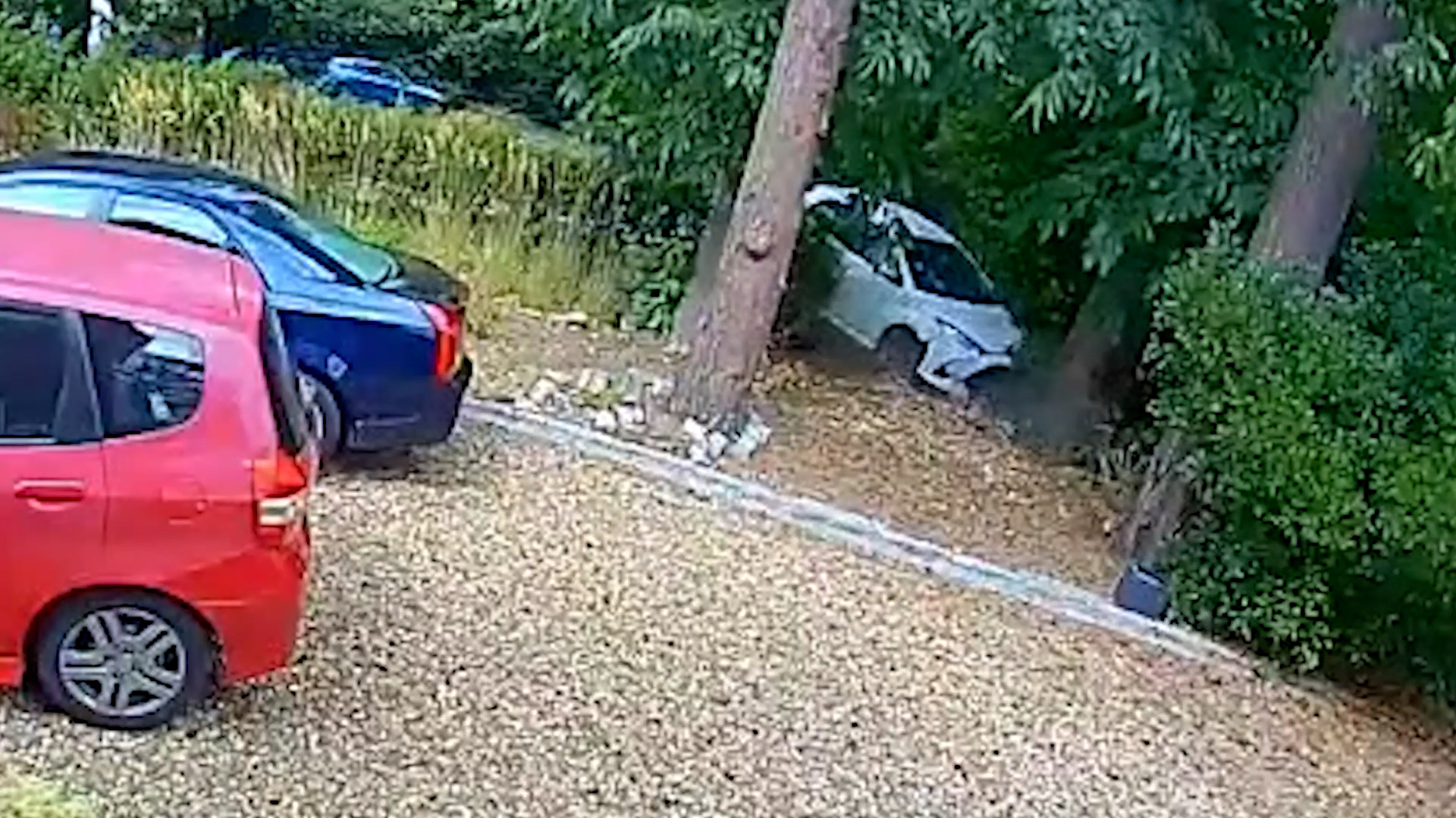 Dramatic moment car flies off road and crashes through garden wall