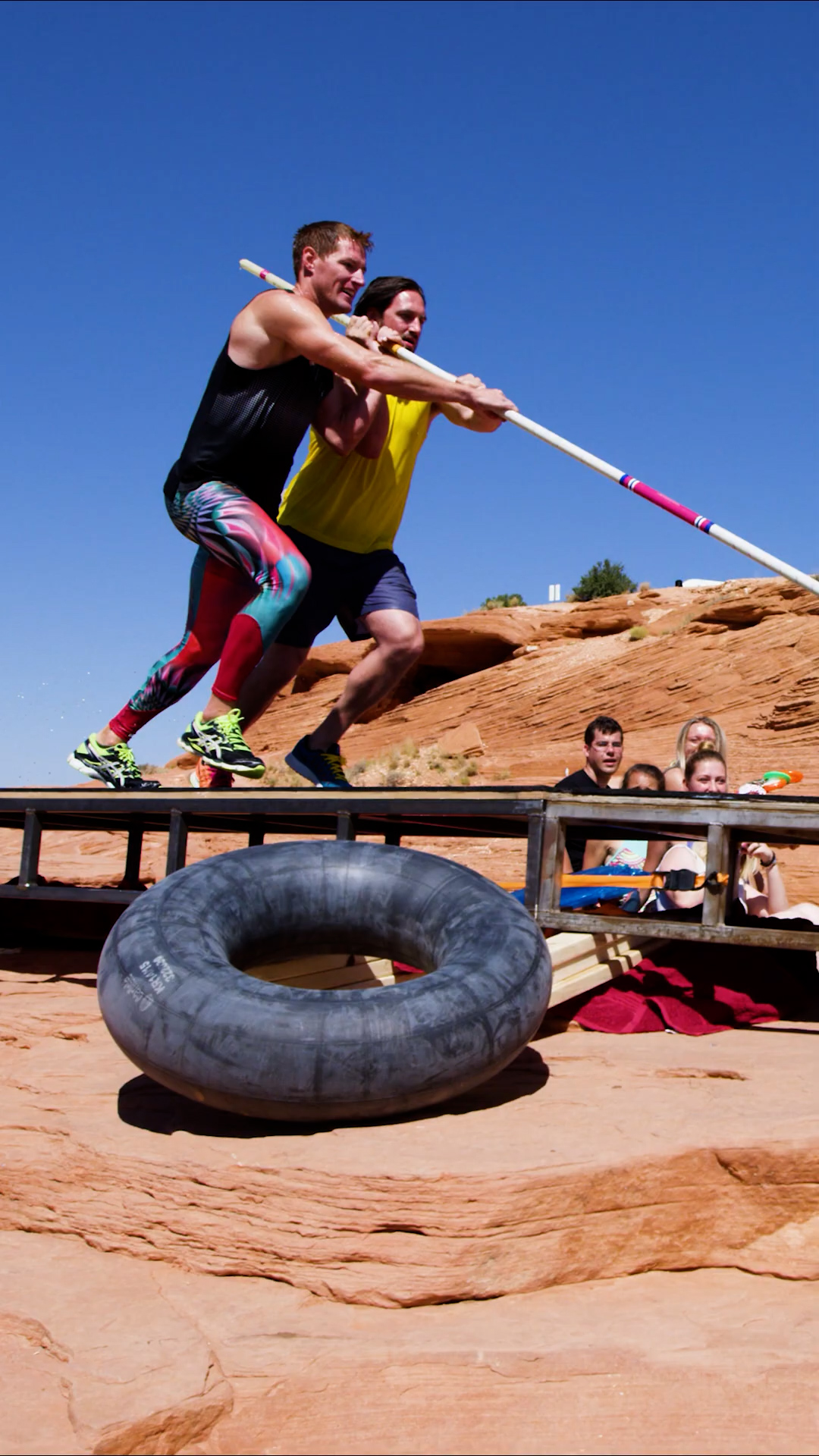 Two Athletes Pole Vault Together