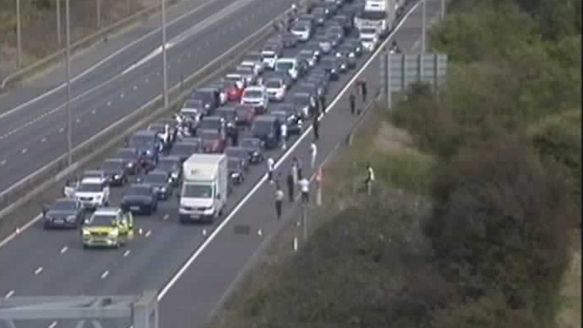 Traffic blocked with people out of cars on motorway