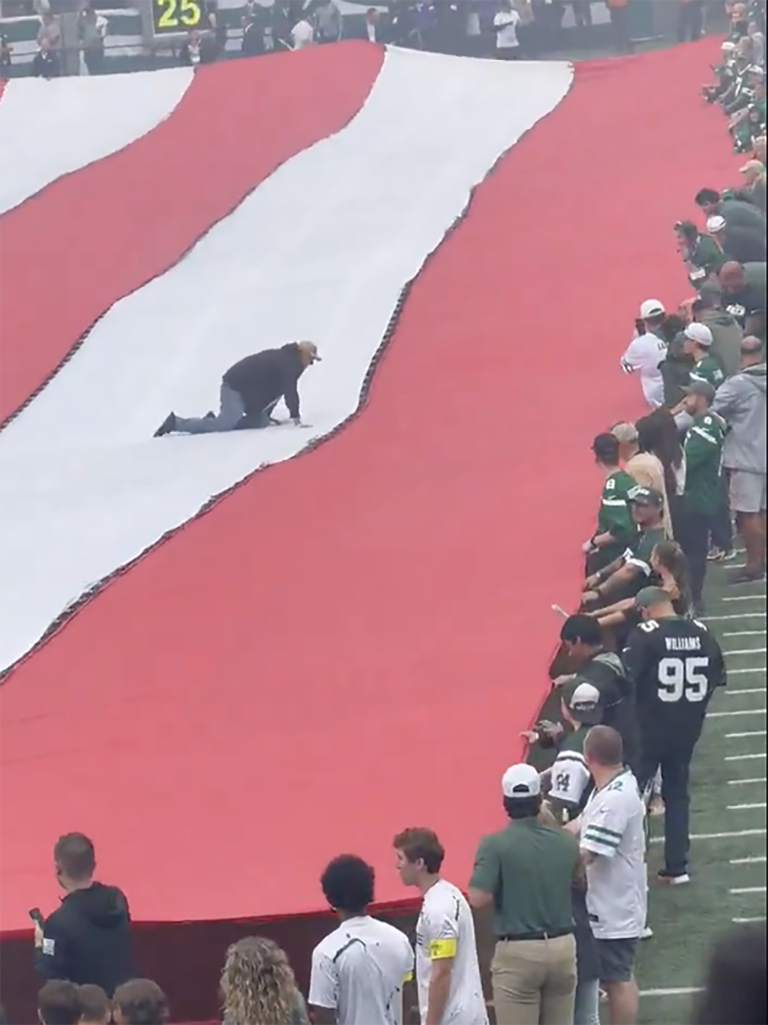 Fan gets stuck on top of massive American flag before Jets-Steelers game