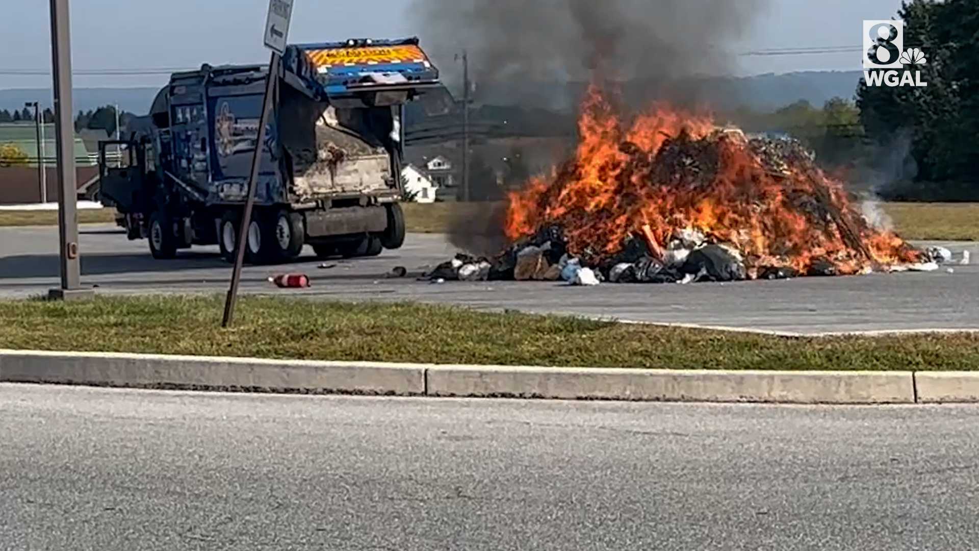 VIDEO | Garbage truck dumps load of burning trash in parking lot