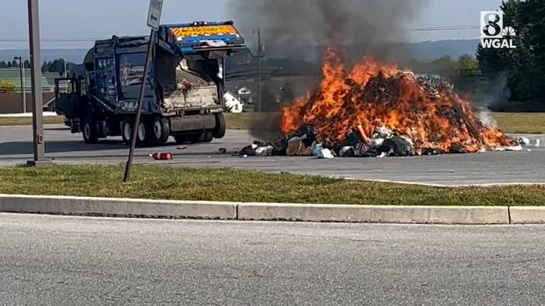 VIDEO | Garbage truck dumps load of burning trash in parking lot