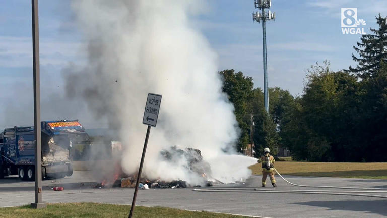 VIDEO | Garbage truck dumps load of burning trash in parking lot