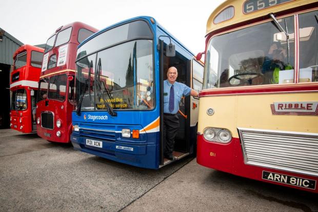Crowds watch vintage buses parade through the Lake District