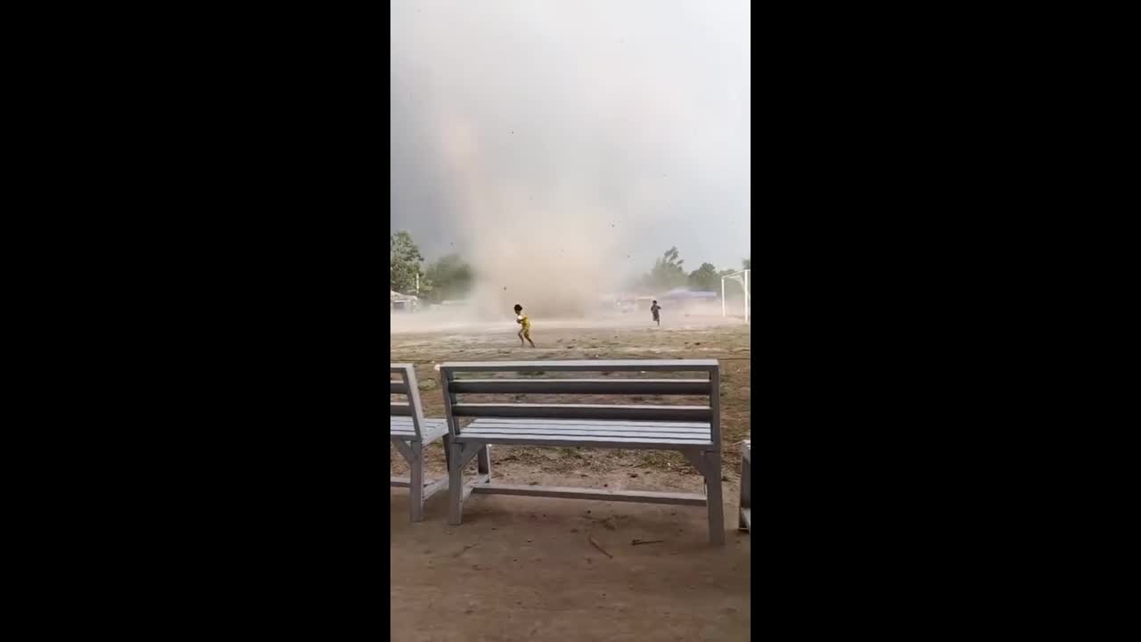 Children flee in panic as sudden dust devil tears across playing field