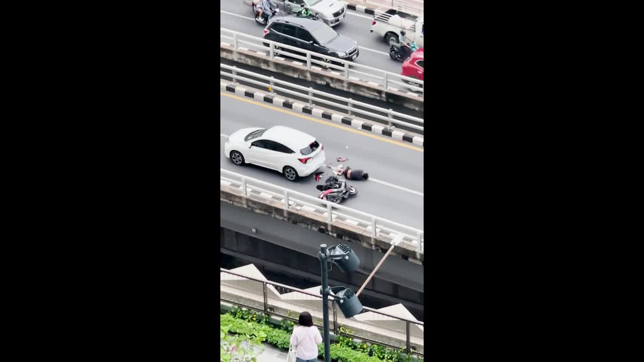 Motorcycle rider knocked over on busy road in Bangkok
