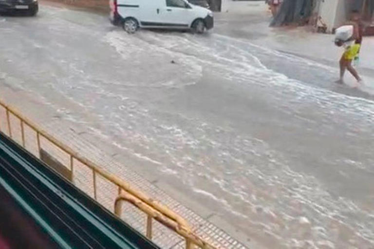 Benidorm floods in freak storm as roads become 'river' and people swim ...