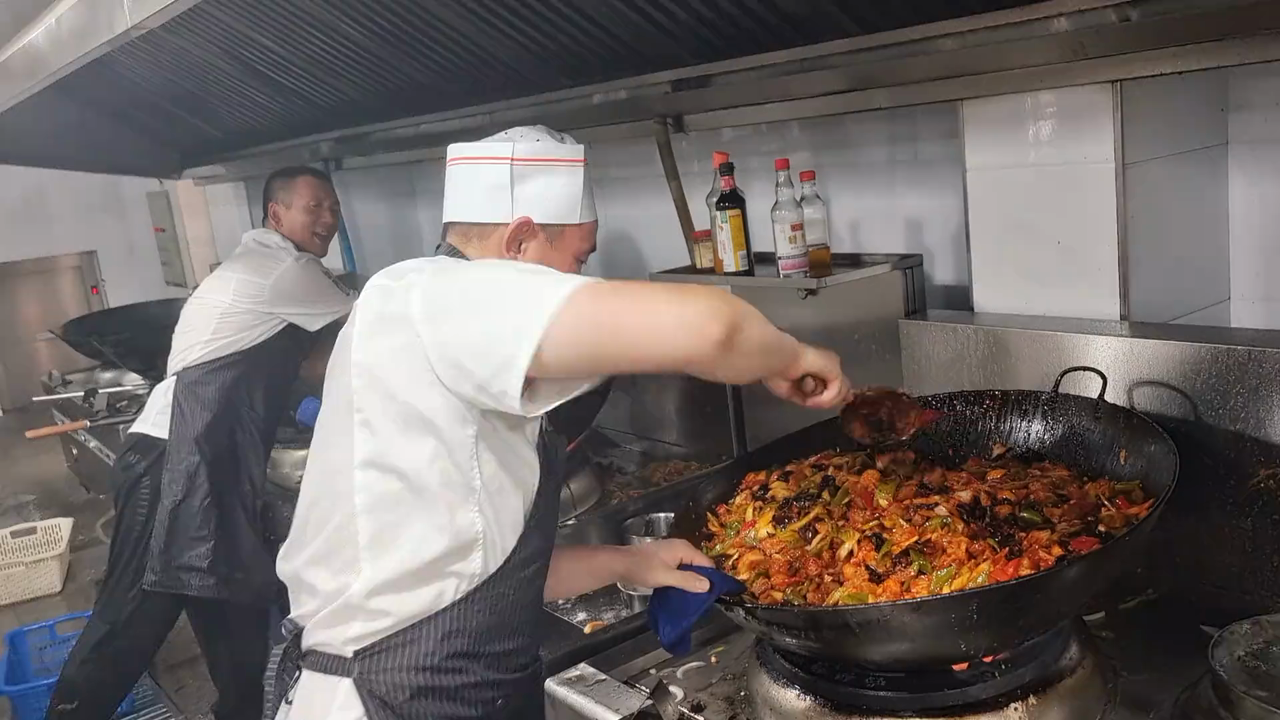 China: Overdreven wokken van chef-kok tijdens groots koken in Jilin, China