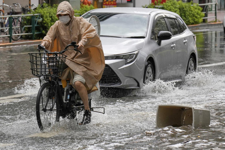 Sudden deluge of rain floods some streets and halts air and rail ...