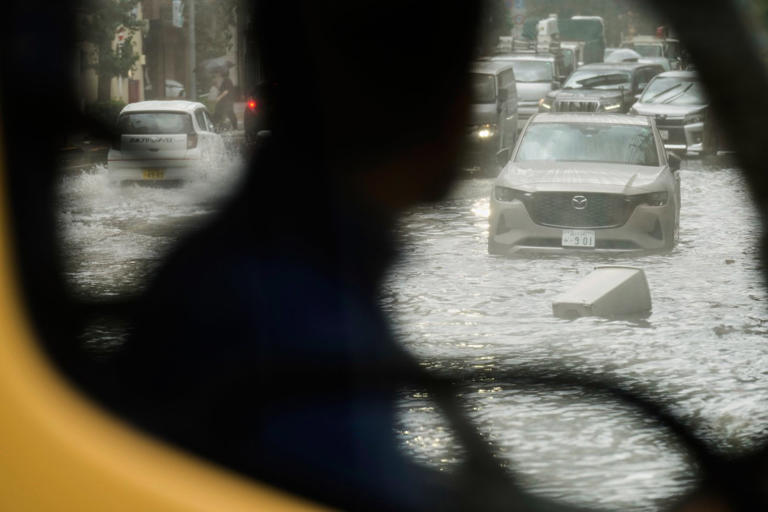 Sudden deluge of rain floods some streets and halts air and rail ...