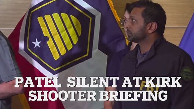 Patel stands oddly and silently during Kirk shooter presser