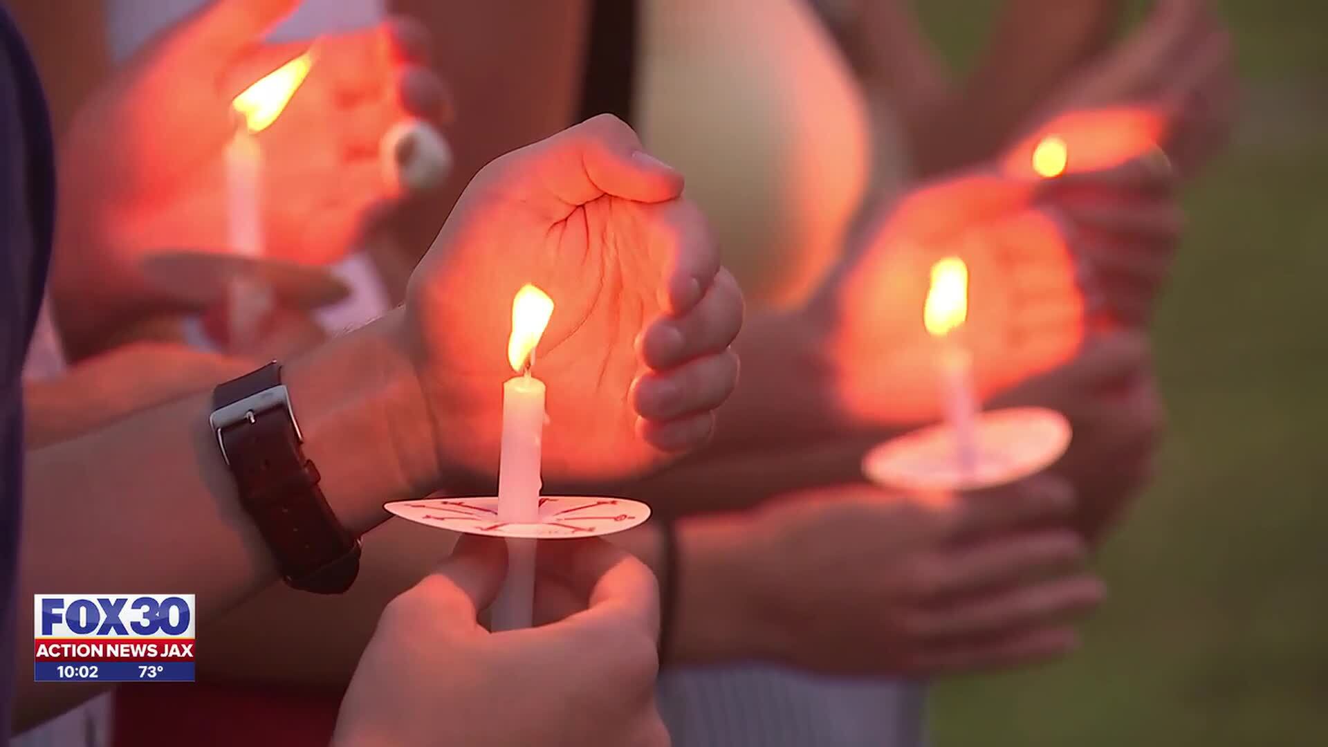 Local leaders and community members gather for candlelight vigil to ...