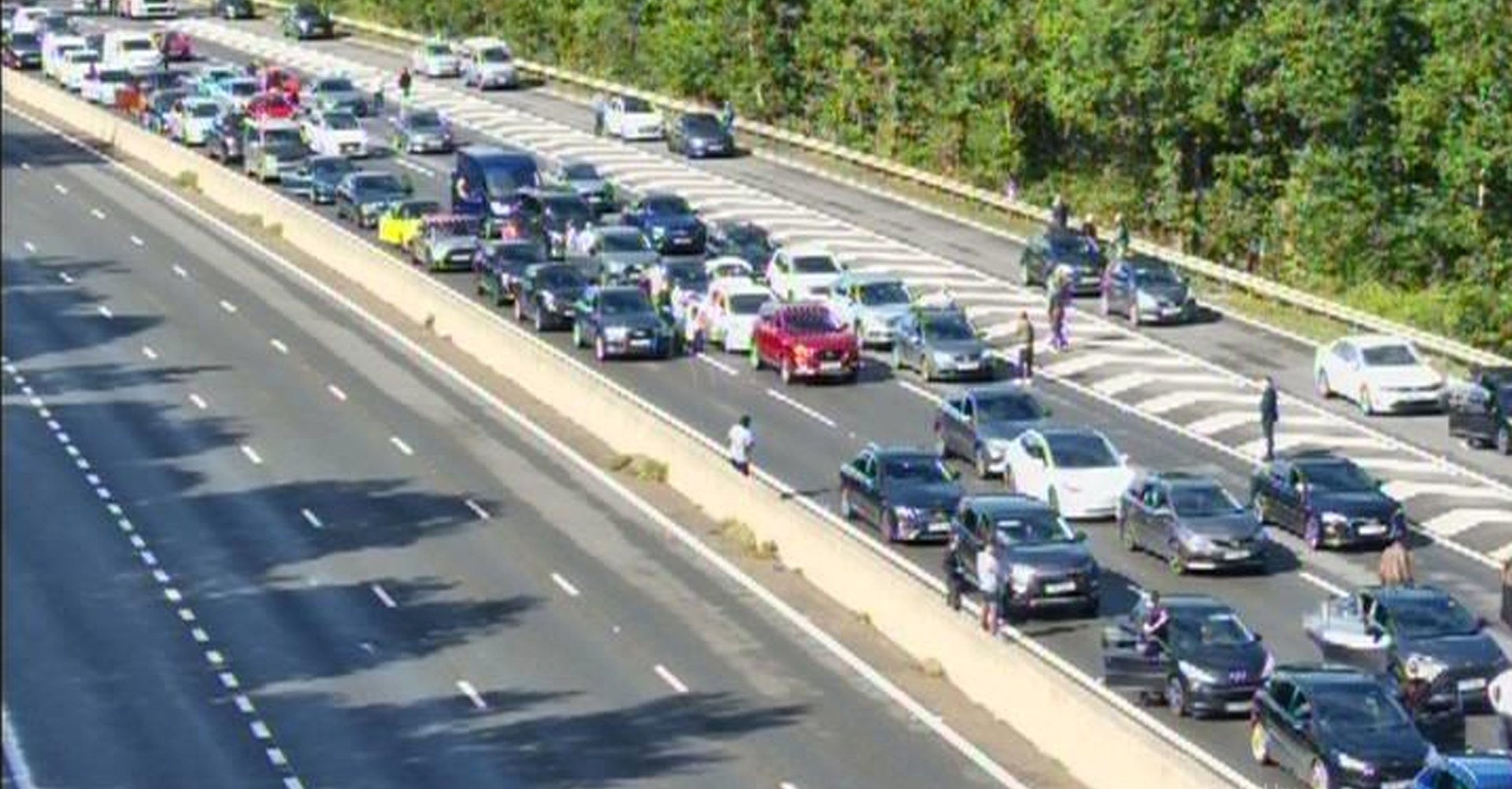 Drivers walk on major motorway and cars face wrong way