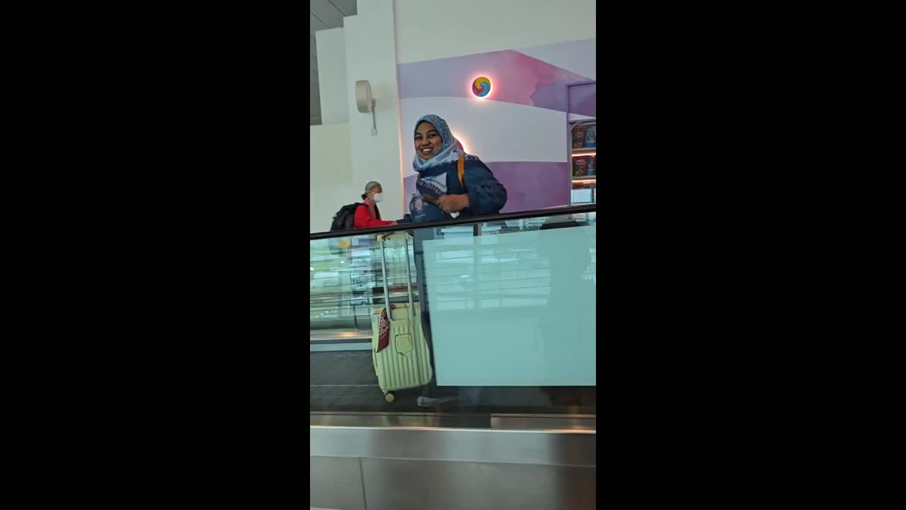 Frantic passenger chases her runaway suitcase on airport travelator