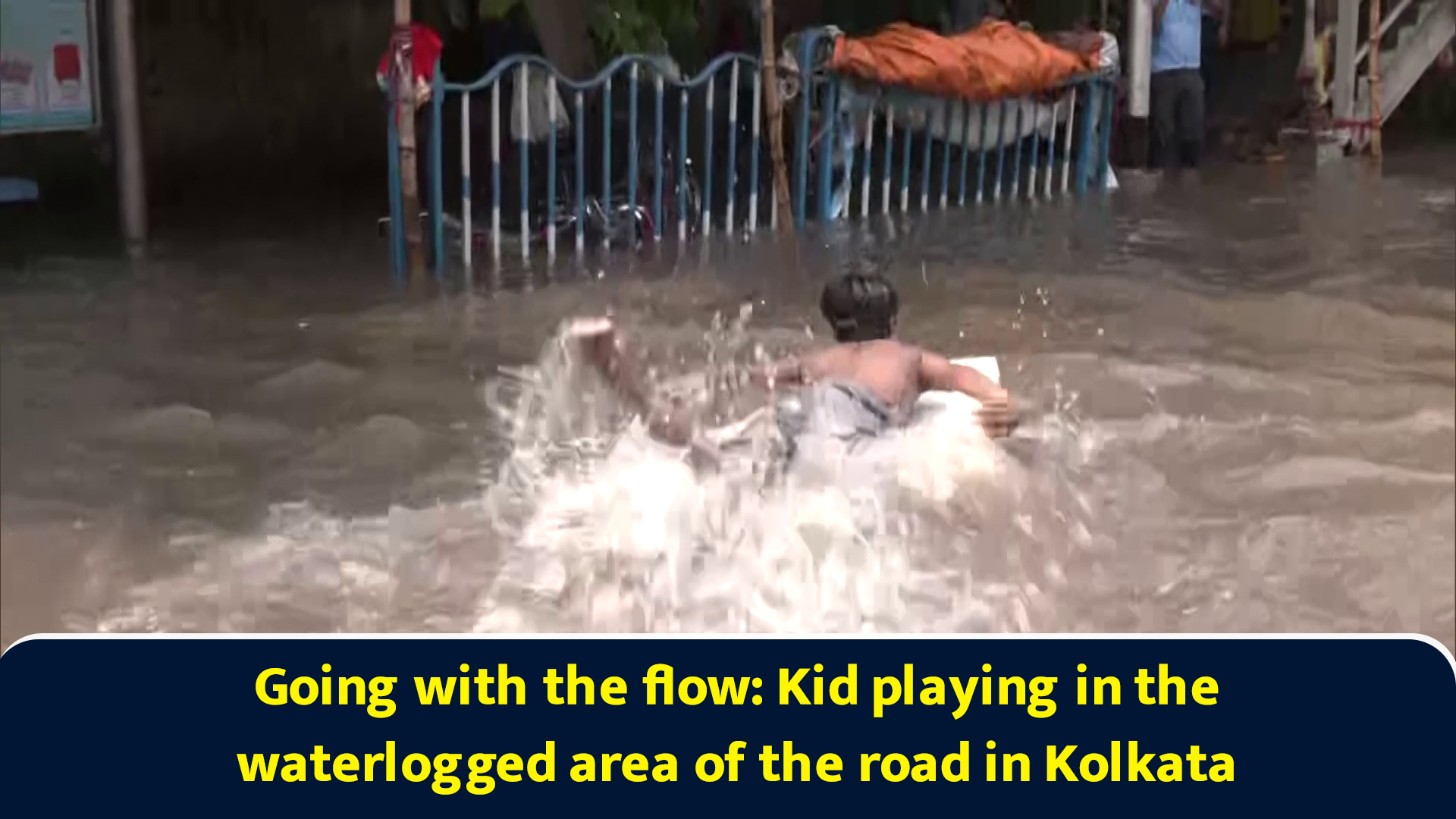 Going with the flow: Kid playing in the waterlogged area of the road in ...