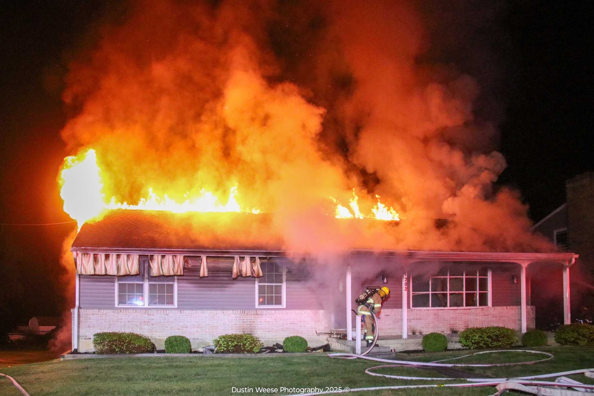 WATCH: Heavy flames shoot through roof of house, firefighter injured
