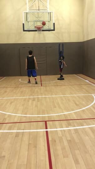 Little Boy Practices Dodging in Basketball with Dad