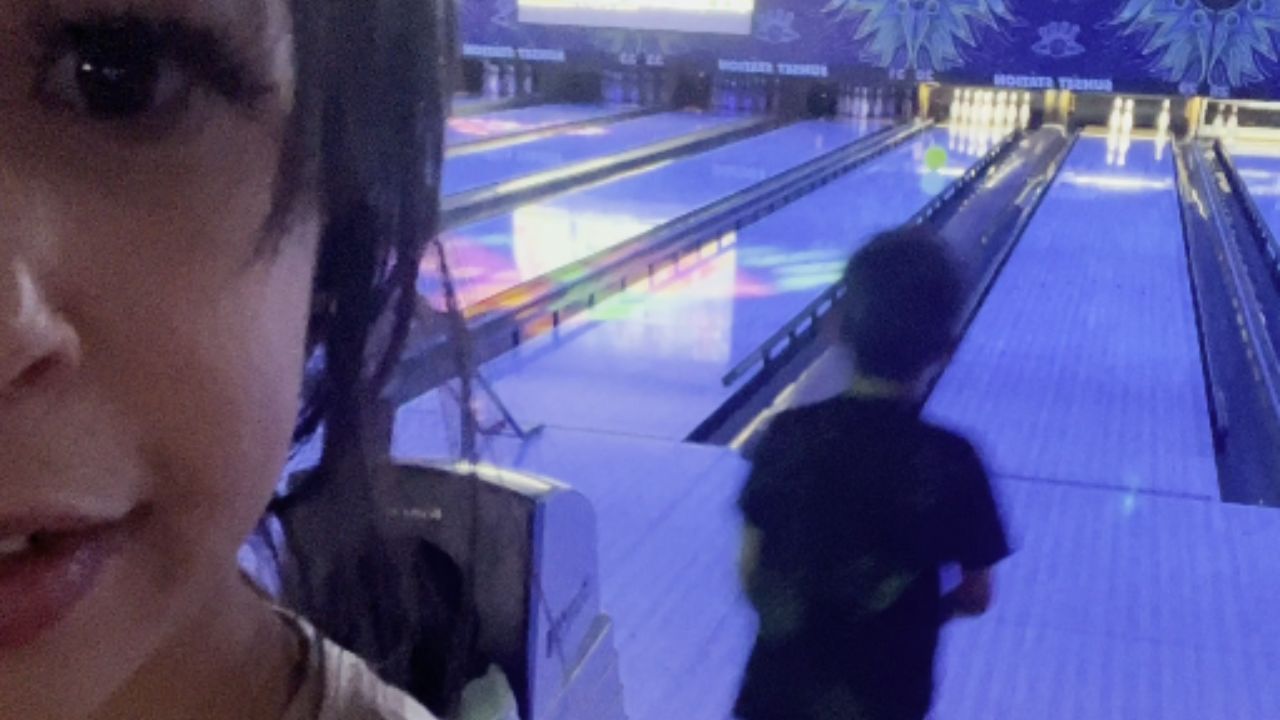 Little boy slips and falls before the bowling ball hits the lane