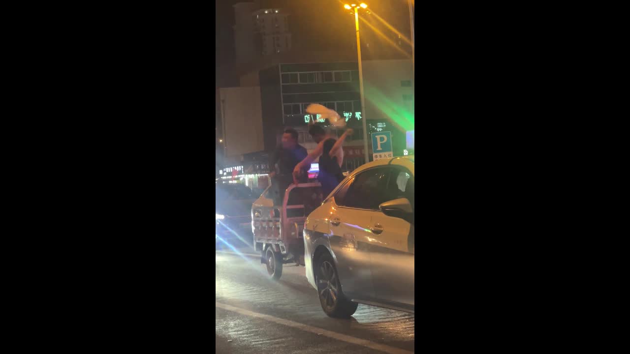 Three men joyfully dance on a moving tricycle in Hebei, China
