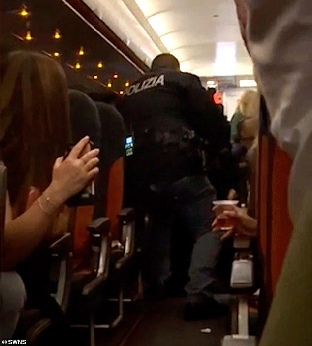 Moment man is dragged off UK easyJet flight by police as passengers cheer