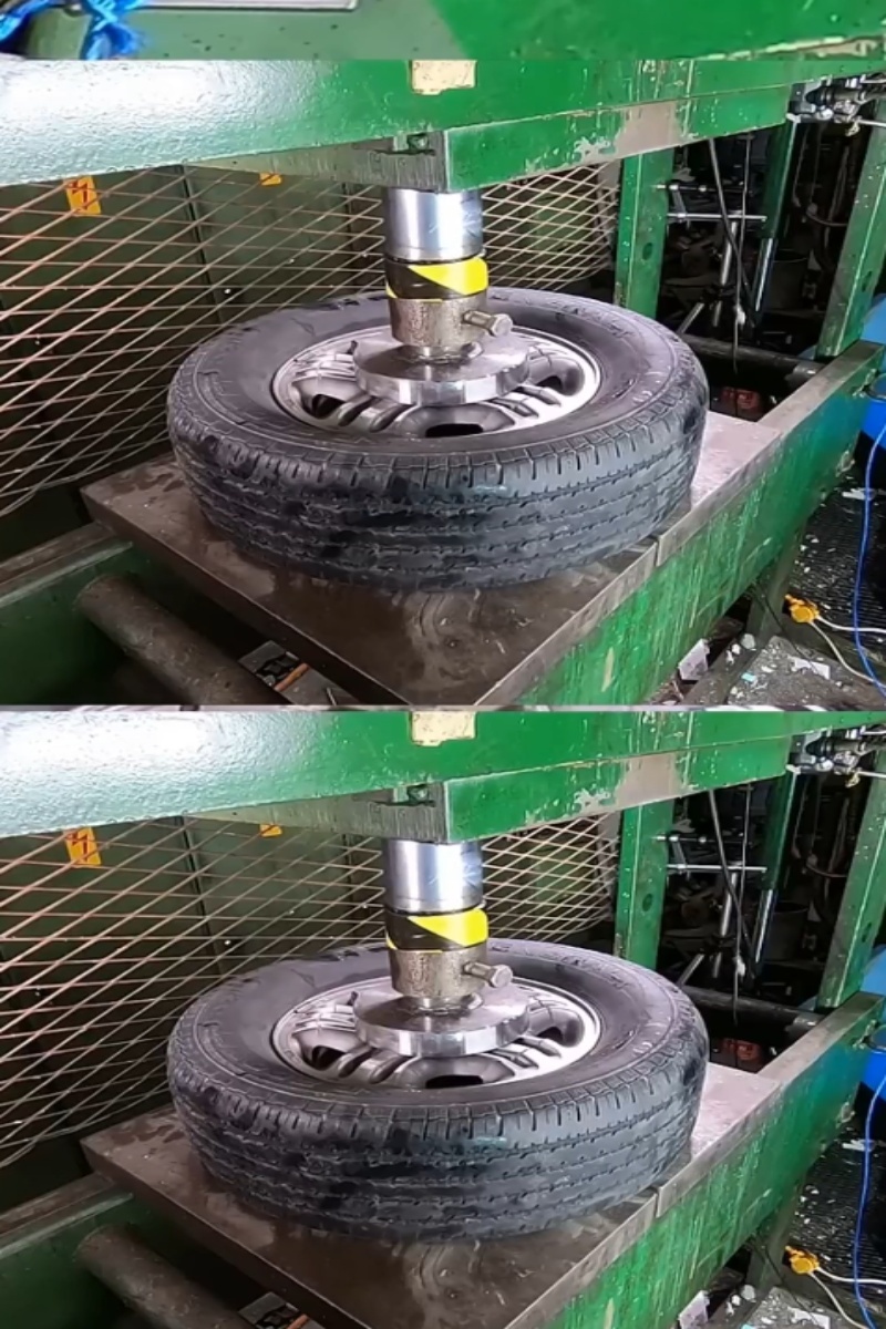 Hydraulische Presse beim Zerkleinern eines Autoreifens