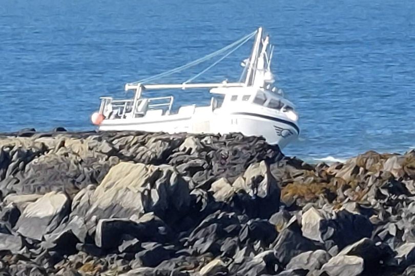 Three people trapped on sinking fishing boat as it hits rocks