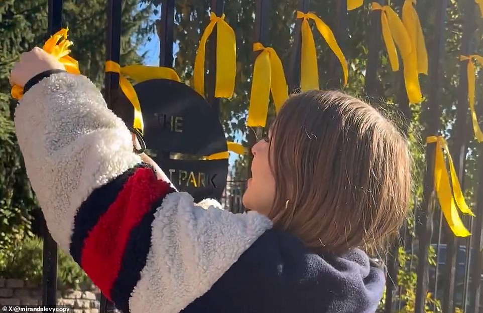 Woman cutting down Israeli hostage ribbons confronted