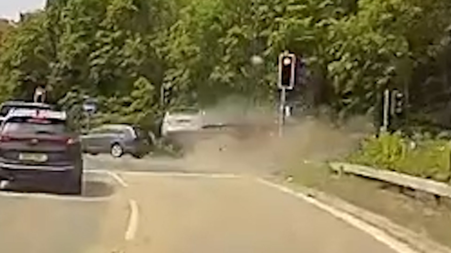 Shocking moment speeding driver runs red light and crashes into roundabout