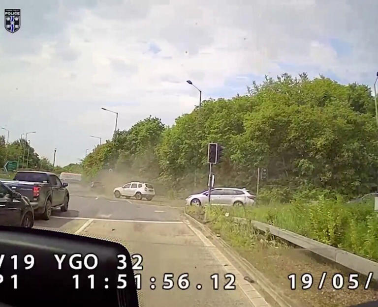 Shocking moment speeding driver runs red light and crashes into roundabout