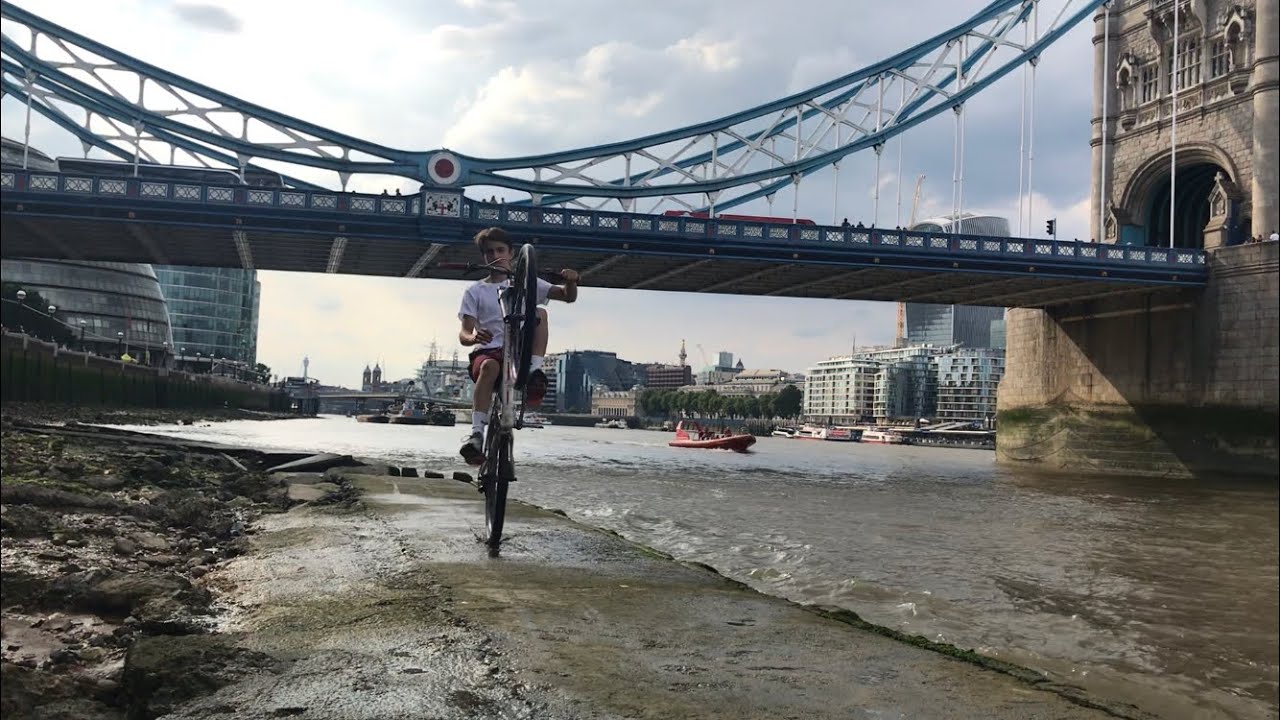 Riding the edge of the River Thames with wheelies