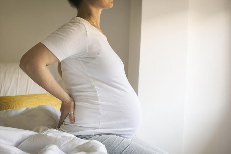 What is causing my lower back pain and swelling in legs and feet?
