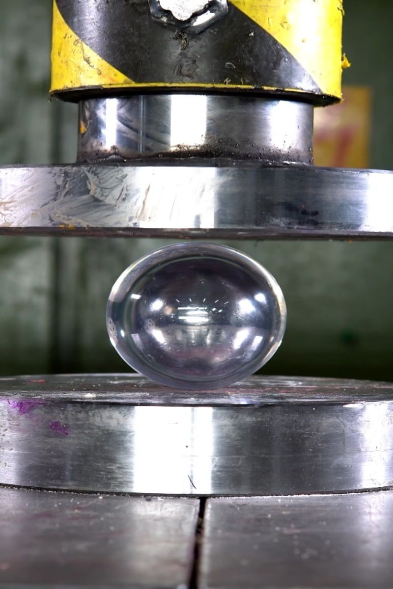 Stalowa kula pod prasą hydrauliczną
