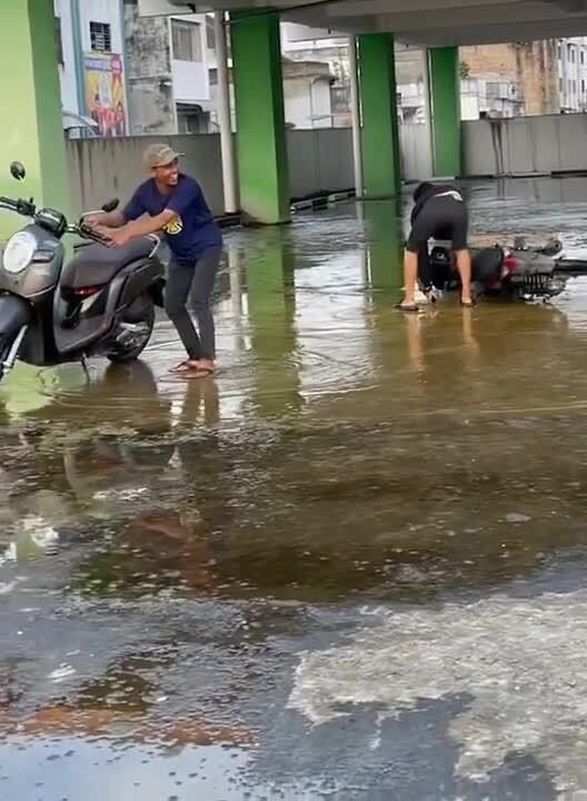 Friends Slip And Fall in Puddle While Struggling to Take Their Scooters Out