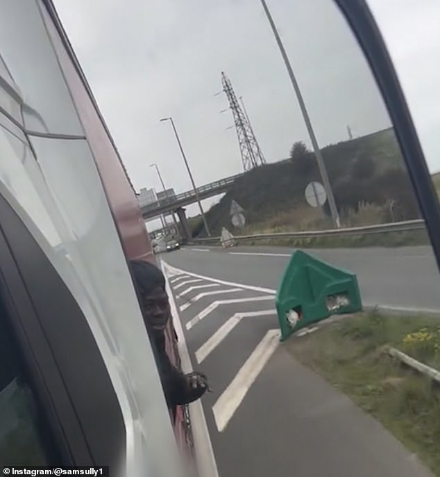 Moment British lorry driver realises stowaway migrant has hitched a ride...