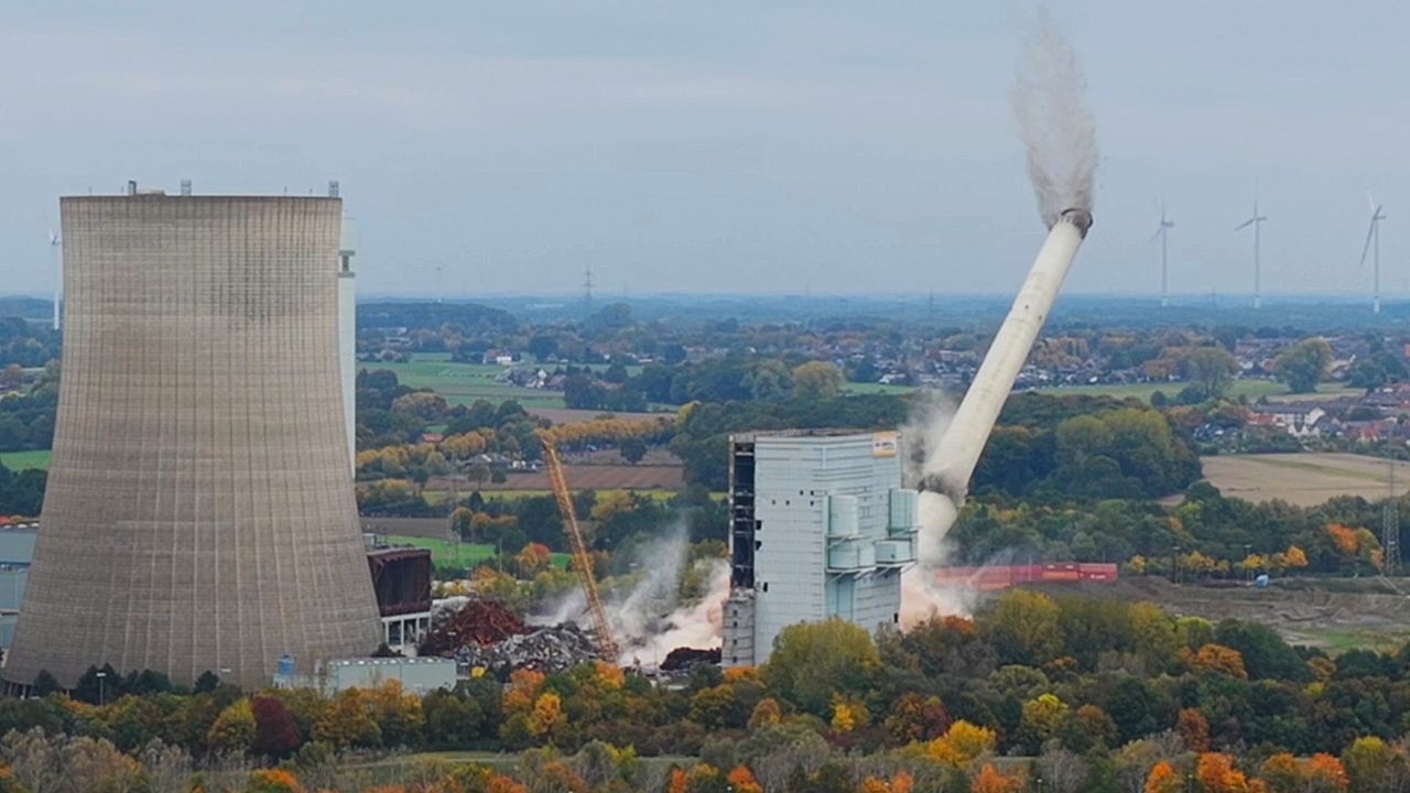 900-foot power plant chimney topples over in controlled demolition