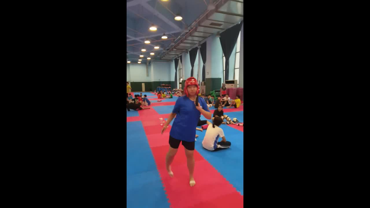 Woman tests helmet durability with fexible side kick in Guangdong, China