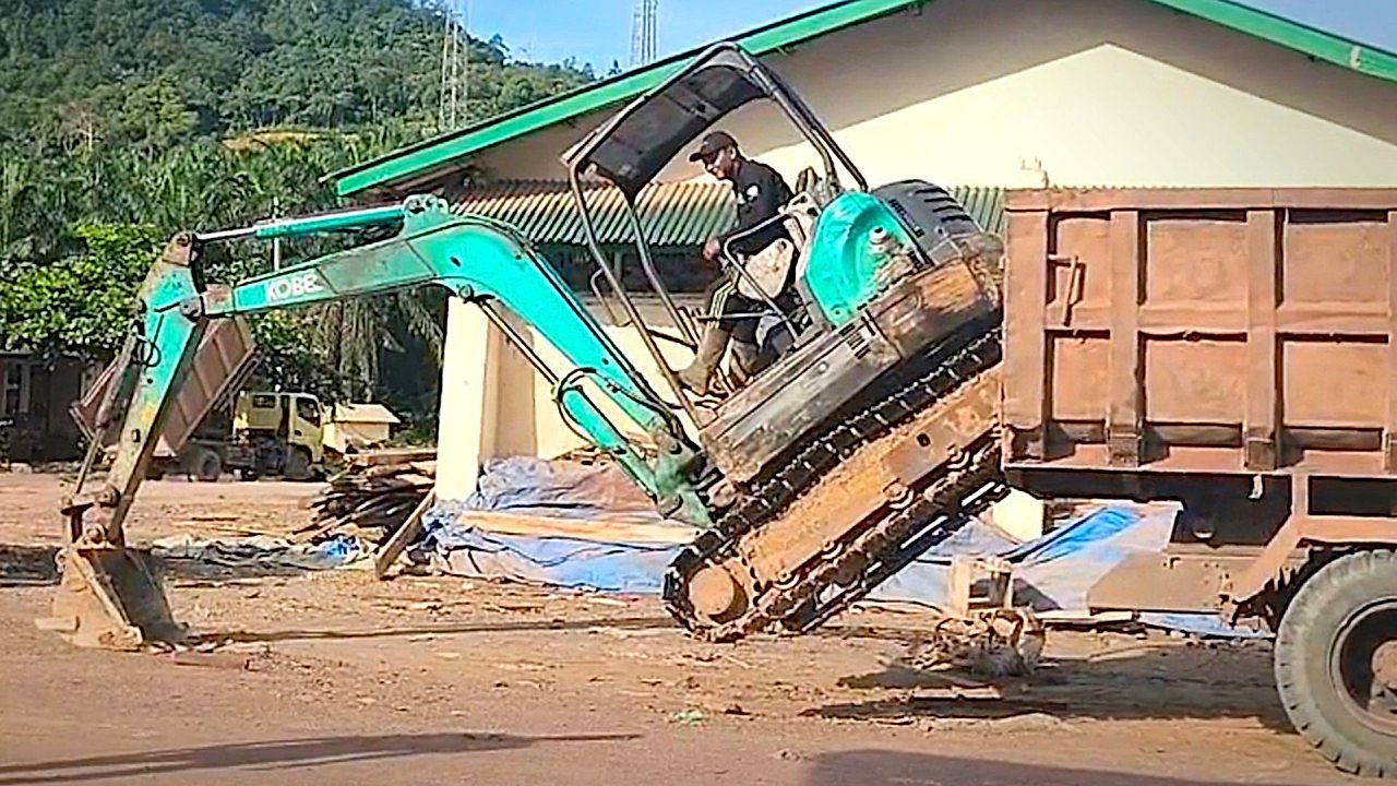 Excavator operator impressively 'climbs down' from truck using bucket