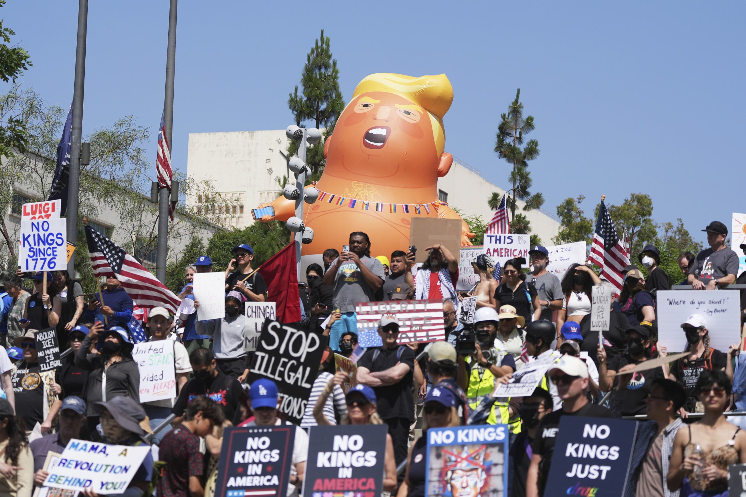 Trump warns US enemies during military parade address, as protests continue