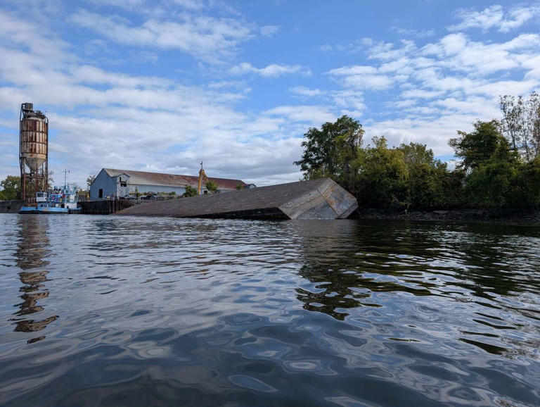 Industrial barge flips in Hudson, remains stuck days later