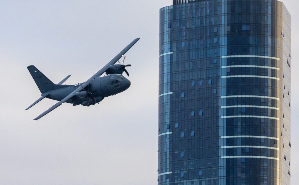 Stunning photos show military aircraft flying through city