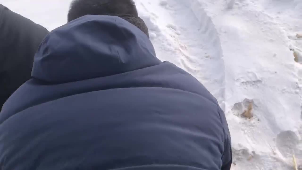 Two men enjoy playful tire sledding in heavy snow in Heilongjiang, China