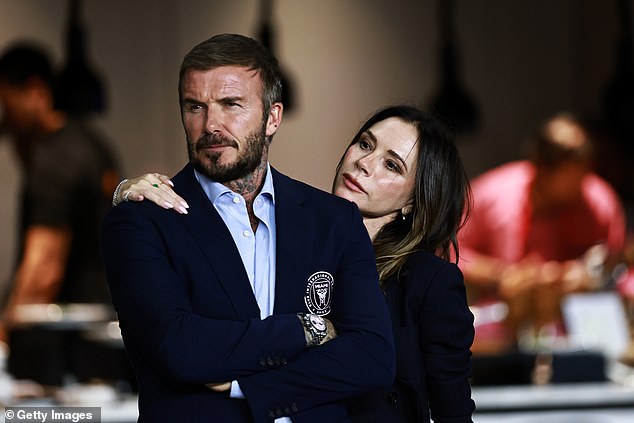 Victoria Beckham is every inch the supportive wife as she wraps her arm ...