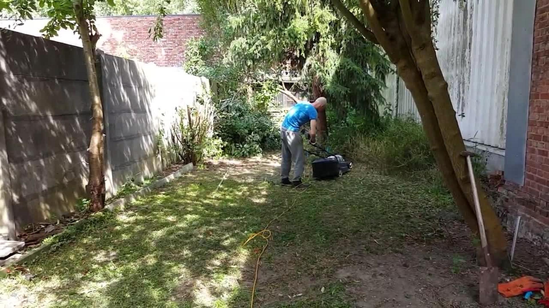 Man Lifts Lawn Mower to Cut Tall Grass