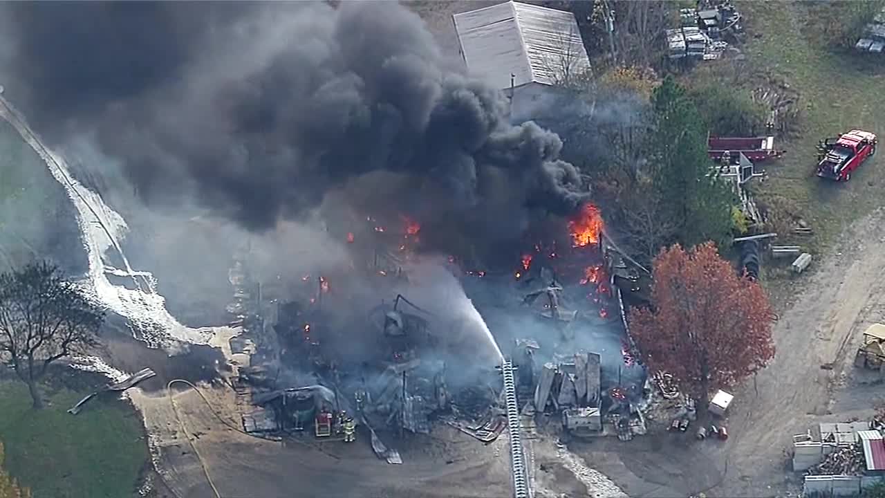 Crews battle massive barn fire in Howell