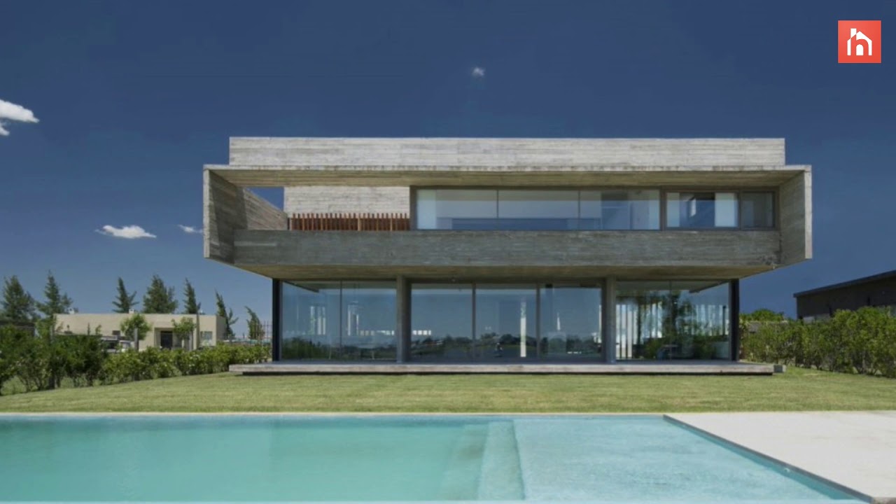 A modern concrete house opens towards a beautiful lagoon
