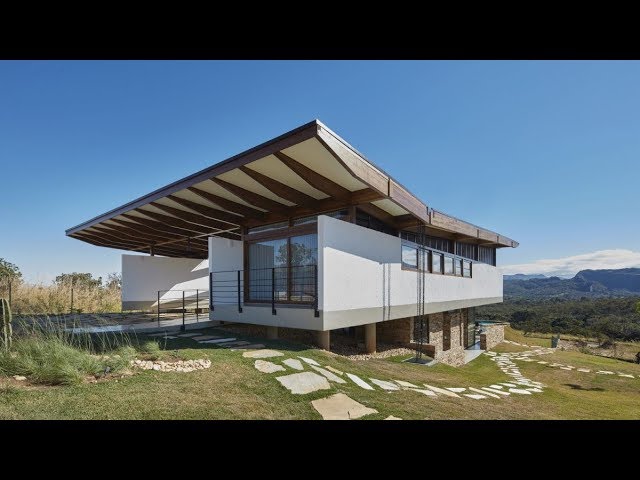A house on a gentle slope embraces its beautiful surroundings