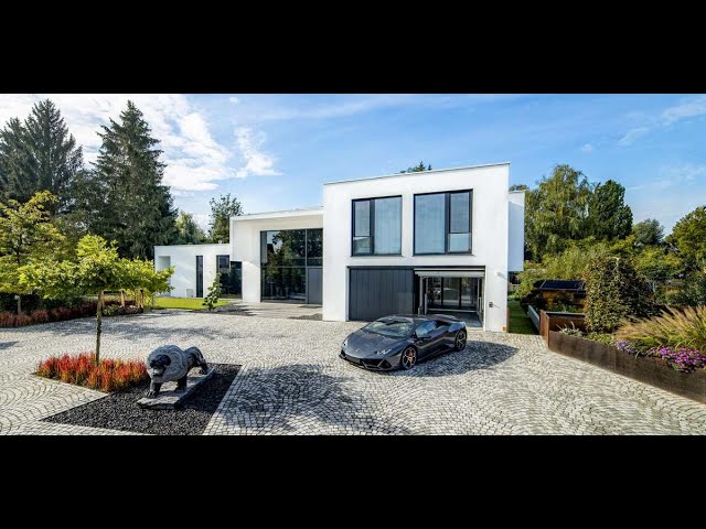 A modern Bauhaus-style villa with a car lift that disappears into the ...