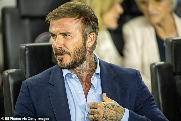 Victoria Beckham is every inch the supportive wife as she wraps her arm ...